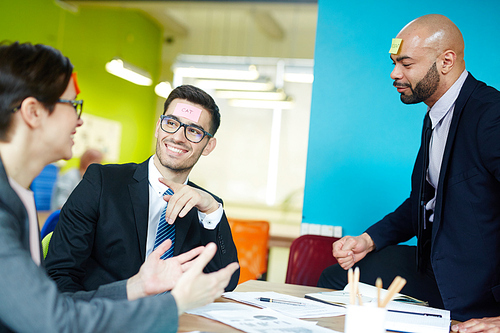 유토이미지 | Group of young business people playing guessing game at table ...