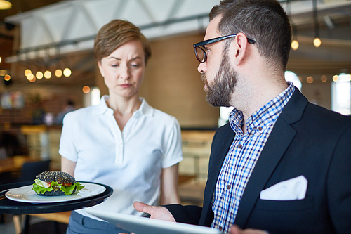 유토이미지 | Bearded young restaurant manager talking to pretty waitress ...