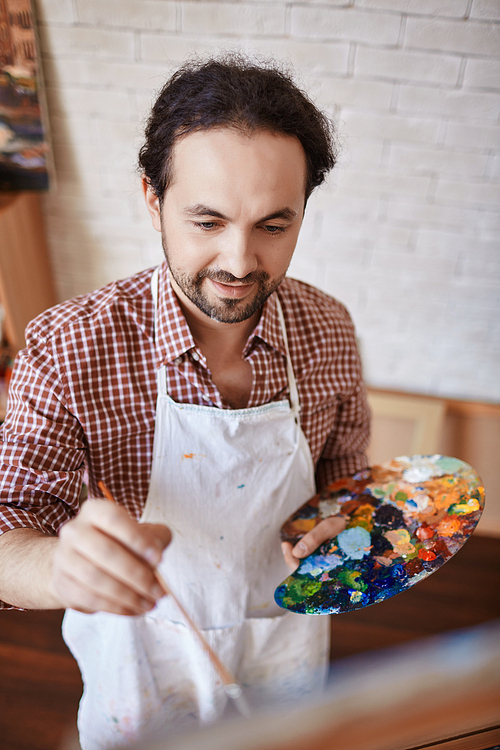 유토이미지 | High angle portrait of talented artist mixing colors on palette ...