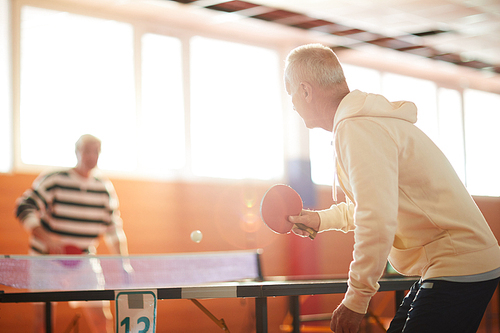 One of active men hitting ping pong ball over table while enjoying game ...