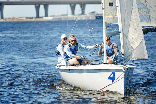 Serious modern men riding on sailboat: young professional yachtsman ...