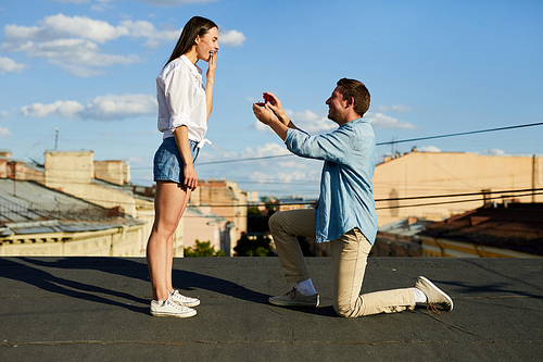 Happy excited girl in casual clothing surprised with marriage proposal ...