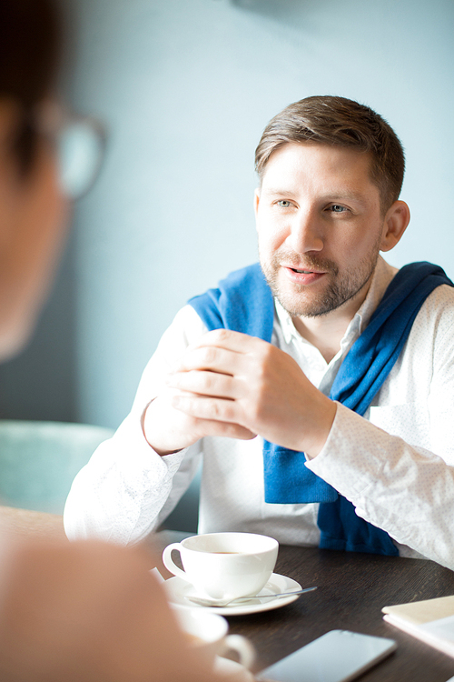 Handsome man in casual outfit sitting at cafe table and having ...