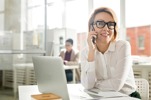 유토이미지 | Smiling businesswoman talking on the phone at her workplace