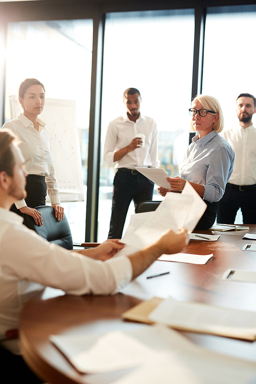 Group of delegates discussing their reports while preparing for ...