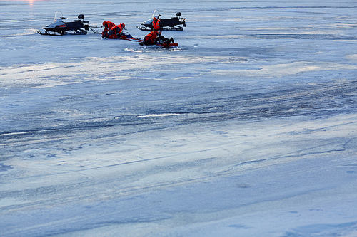 유토이미지 | Lifeguards on snowmobiles giving first aid to drown victim