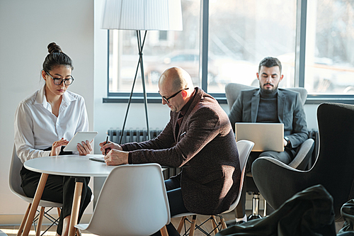 Group of intercultural busy co-workers in formalwear sitting in hotel ...