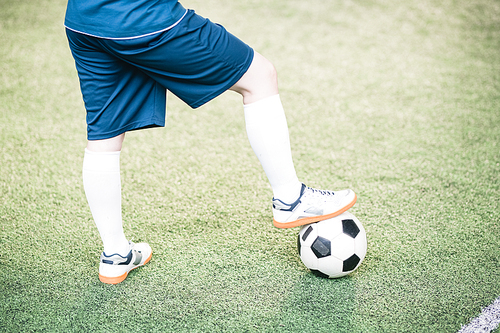 유토이미지 | Young female football player in blue uniform keeping right foot ...