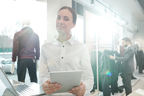 유토이미지 | Pretty shop assistant in white shirt using touchpad by ...