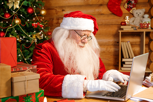 Serious Santa concentrating on answering electronic letters while ...