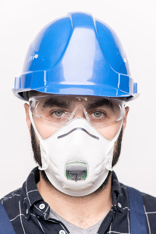 Head of young engineer or builder in hardhat and protective mask ...