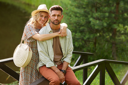 Portrait of romantic adult couple embracing and while posing on wooden ...