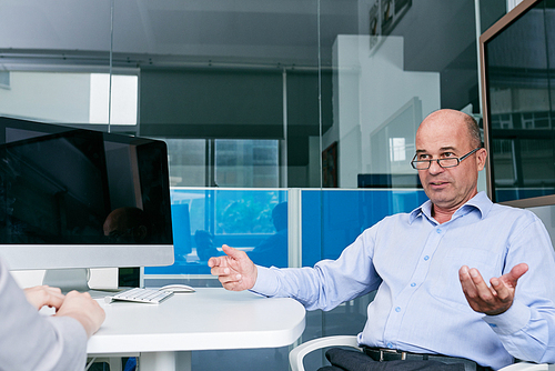 유토이미지 | Waist-up portrait of confident middle-aged HR manager sitting ...