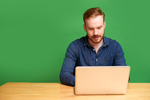 유토이미지 | Handsome young software developer sitting at green wall and ...
