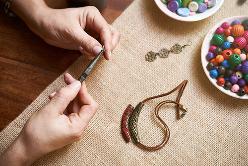 유토이미지 | Close-up of woman making handmade necklace and beading from ...