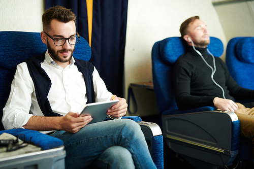 Portrait of two handsome men enjoying first class flight in comfortable ...