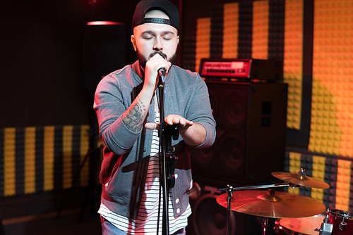 유토이미지 | Waist up portrait of bearded hip-hop musician performing in dim ...