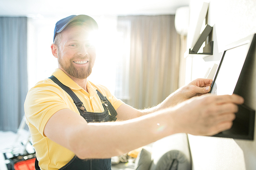 유토이미지 | Jolly handsome young bearded handyman in cap standing in living ...