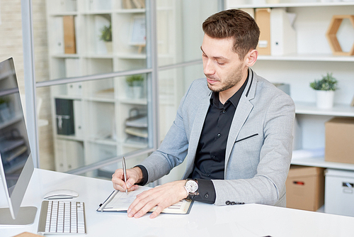 유토이미지 | Portrait shot of confident young manager taking notes while ...