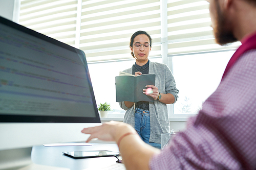 유토이미지 | Man working on computer in office while his female coworker ...