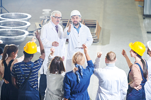 High angle portrait of two business people talking to group of angry ...