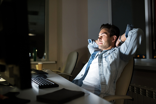 Portrait of handsome man chilling while using computer sitting at desk ...