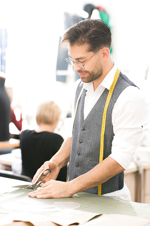 유토이미지 | Side view portrait of mature male tailor cutting fabric and ...