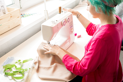 High angle portrait of creative young woman making clothes sitting at ...