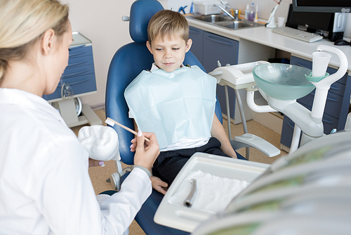 유토이미지 | Portrait of brave little boy sitting in dental chair and ...