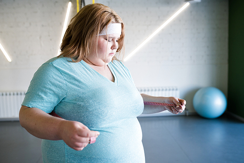 유토이미지 | Waist up portrait of obese young woman measuring waist size ...
