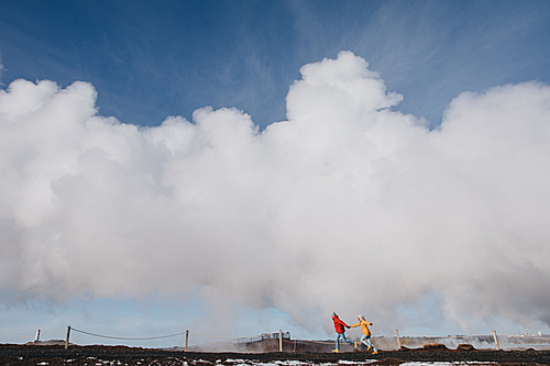 young couple holding hands and running near geothermal hot springs in ...