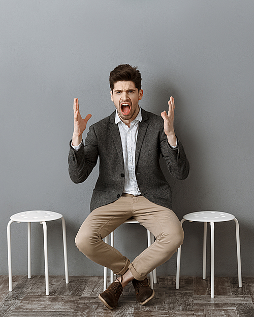 frustrated businessman in suit gesturing while waiting for job ...