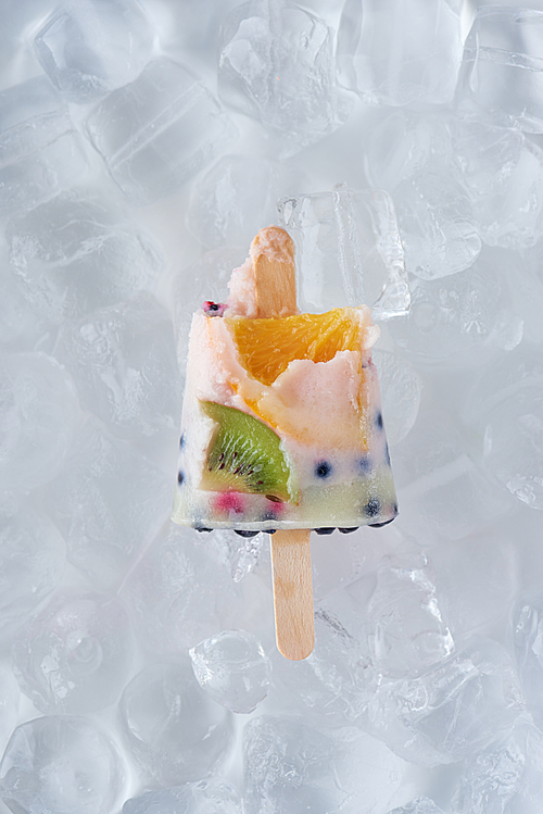 close-up view of half on homemade popsicle with fruits and berries on ...