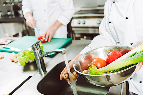 유토이미지 | cropped view of female chef washing vegetables in restaurant ...