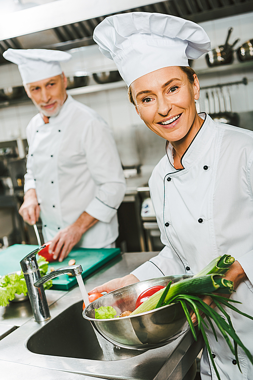 beautiful female and male chefs in double-breasted jackets during ...
