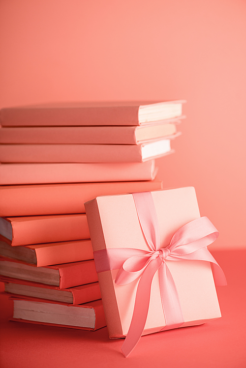 유토이미지 | stack of books and gift box in living coral color. Pantone ...