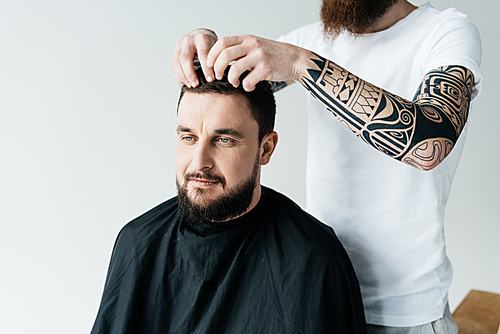 cropped image of barber styling customer hair at barbershop isolated on ...