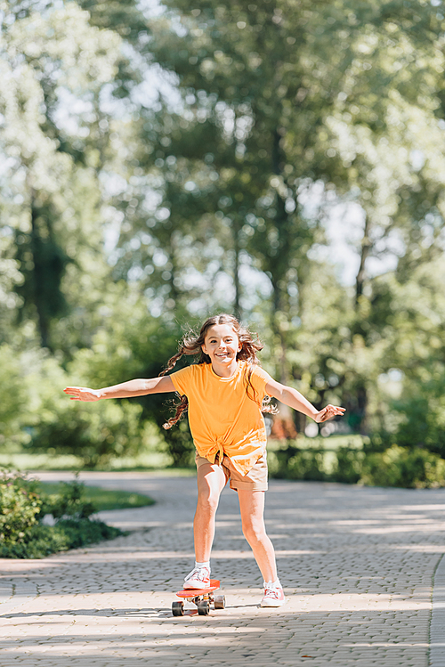 유토이미지 | beautiful happy kid riding skateboard and smiling at camera in park