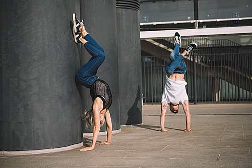 유토이미지 | young couple of dancers performing handstand on street