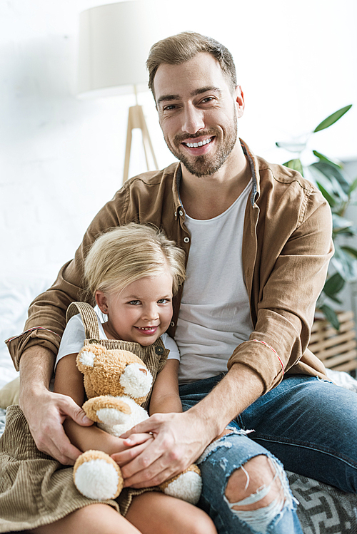 happy father and daughter with teddy bear sitting together at home | 유토 ...