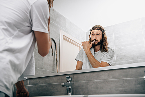 partial view of Jesus with towel over shoulder brushing teeth and ...