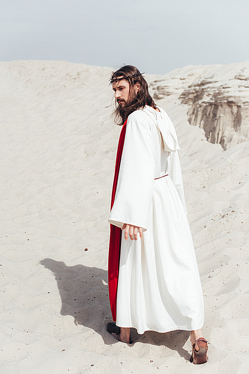 back view of Jesus in robe, red sash and crown of thorns walking in ...