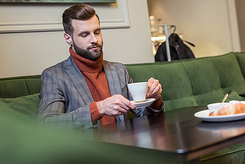 selective focus of handsome man in formal wear sitting at table and ...