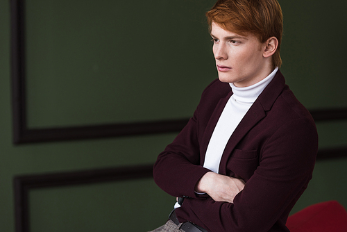 유토이미지 | Side view of male model in jacket sitting on couch