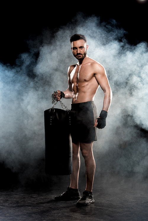 handsome boxer holding punching bag on black with smoke | 유토이미지 | 상세페이지 ...