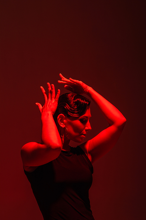 expressive dancer performing tango on dark background with red lighting ...