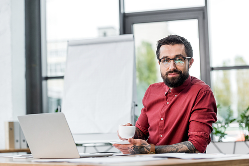 smiling account manager sitting at table and holding cup of coffee | 유토 ...