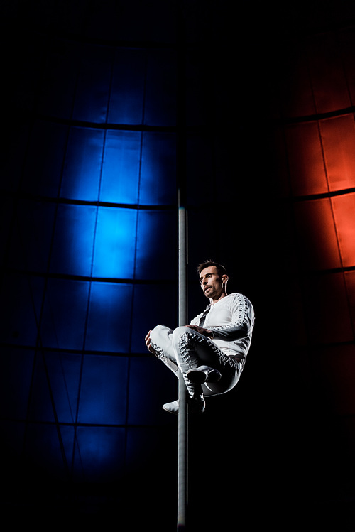 유토이미지 | handsome and strong acrobat performing on metallic pole