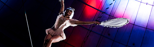 panoramic shot of attractive 공중 acrobat holding racket while standing ...
