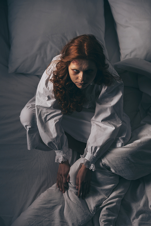 유토이미지 | overhead view of demoniacal scary woman in nightgown sitting in bed
